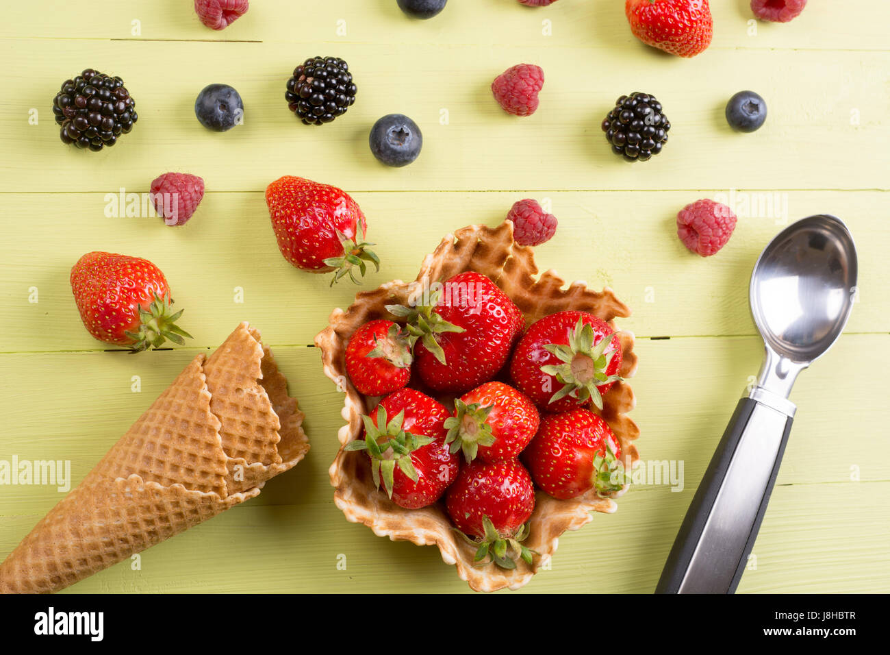 Ingredients for ice cream - cones and fresh fruits on wooden table. Top ...