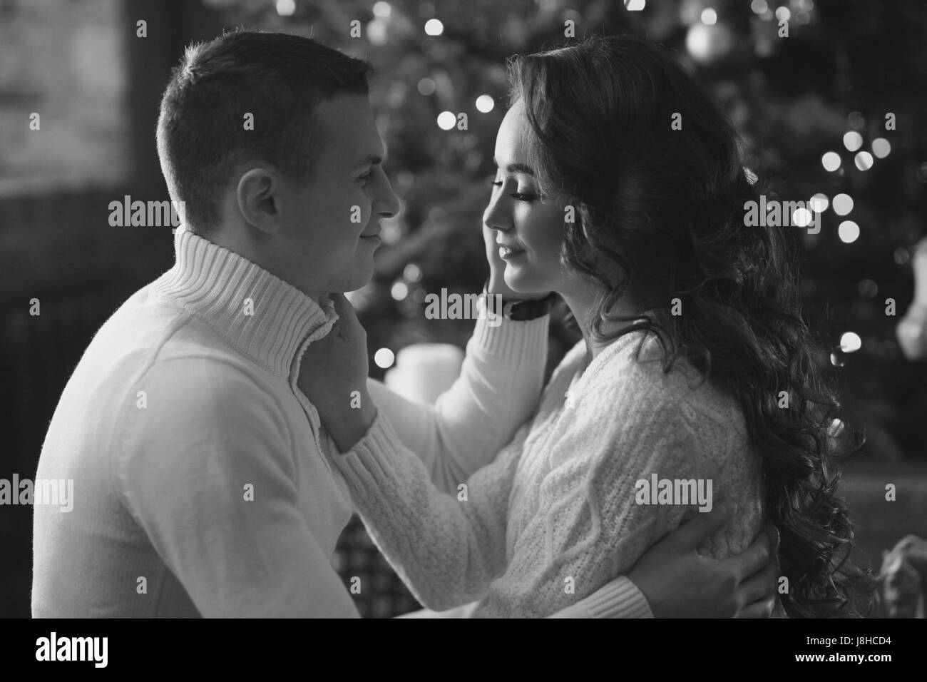 Young couple staying at home together on holiday evening and sitting on ...