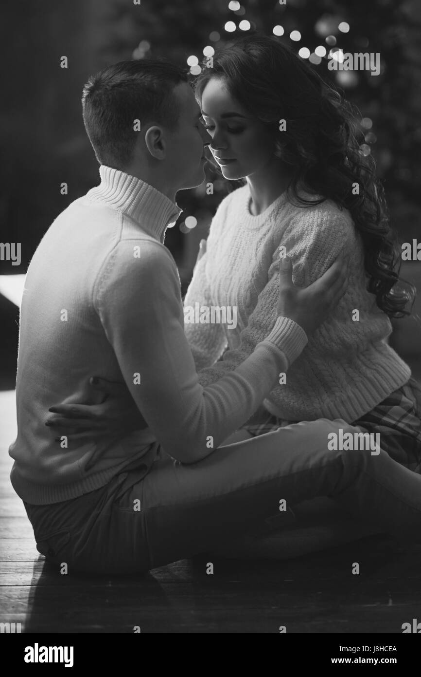 Young couple staying at home together on holiday evening and sitting on ...