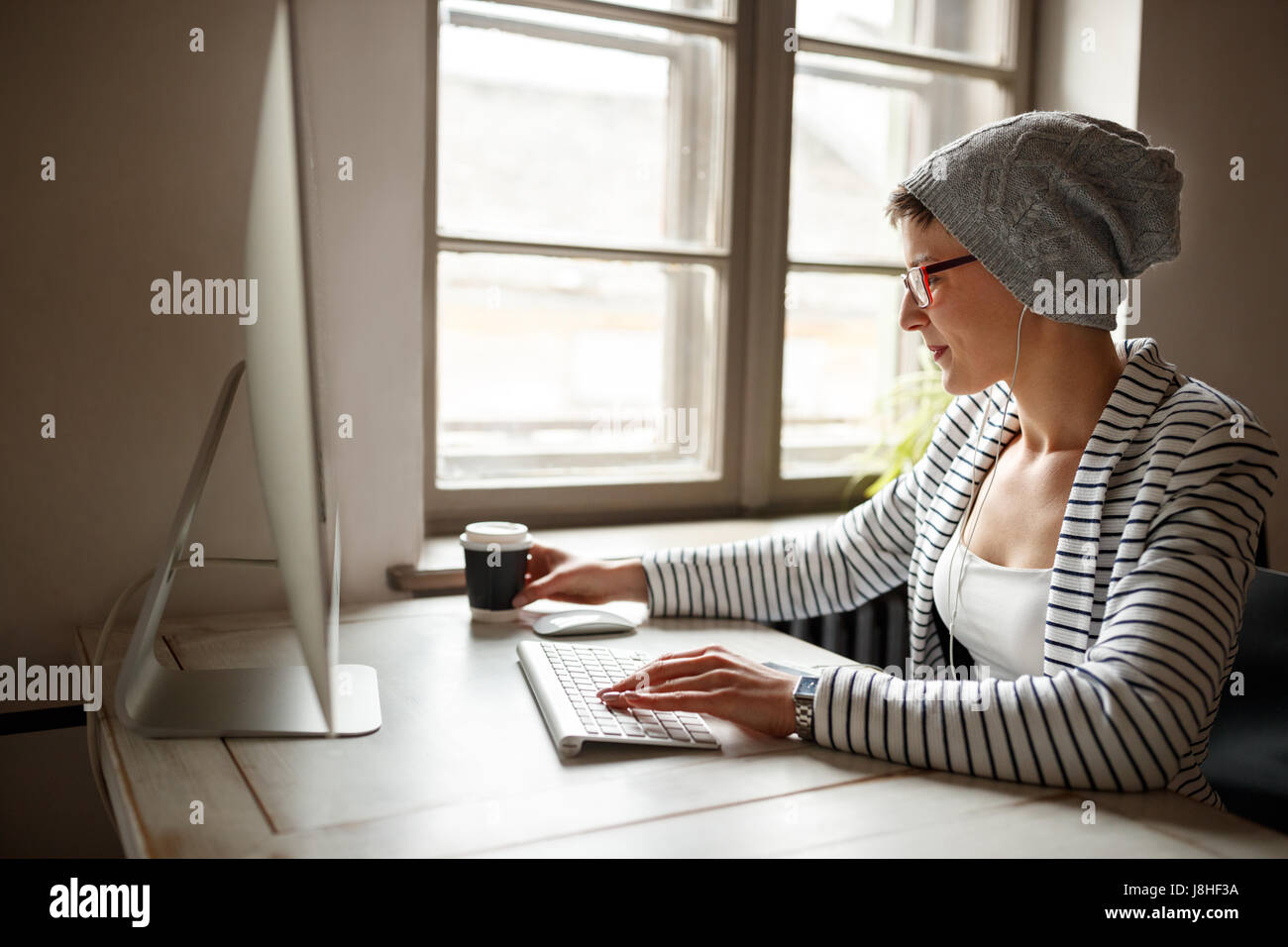 Female working on computer and drinking coffee at workplace Stock Photo ...