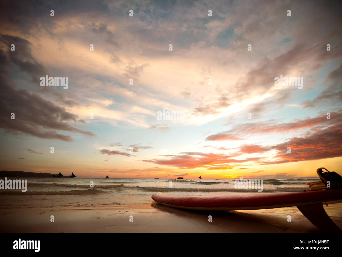 beach with surfboard on the shore at sunset Stock Photo - Alamy