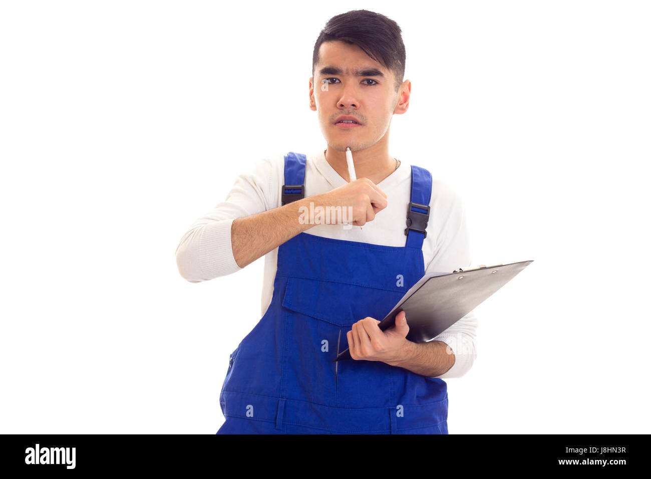 Young unkind man with dark hair wearing in white shirt and blue overall ...