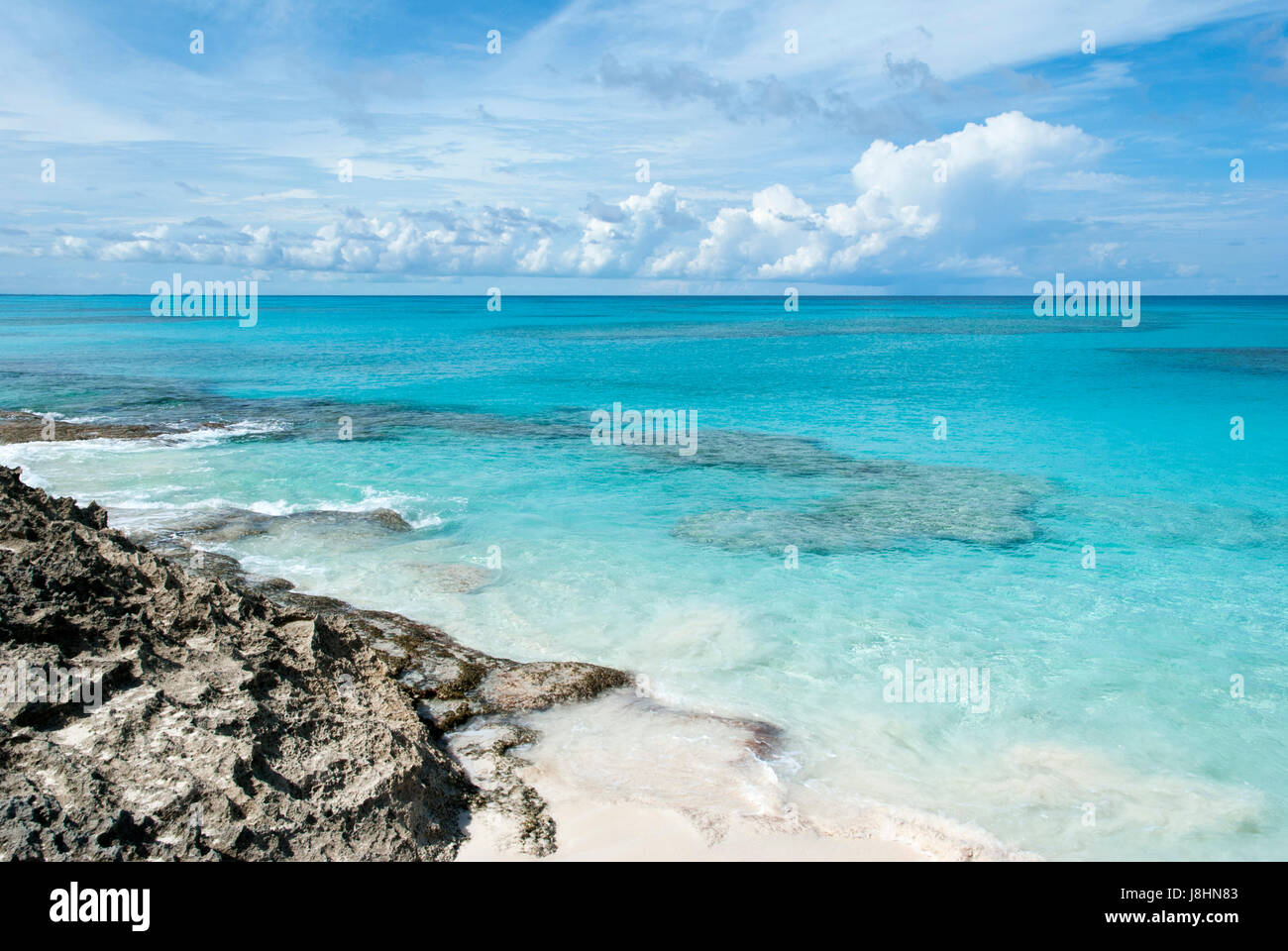The transparent waters along rocky coastline of uninhabited island Half ...