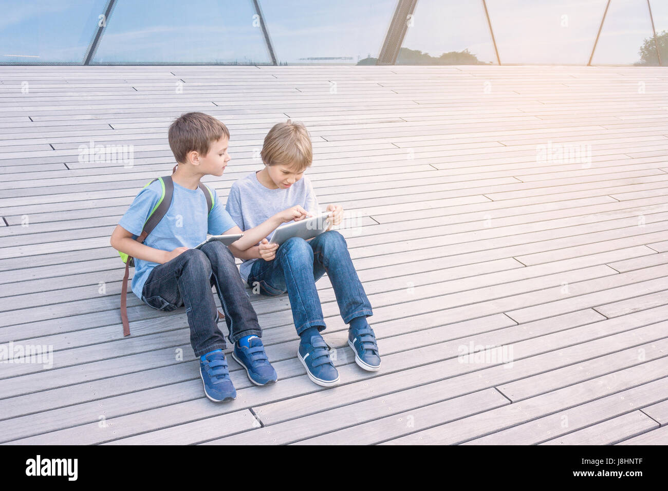 Children playing with tablet computer outdoor. People education ...