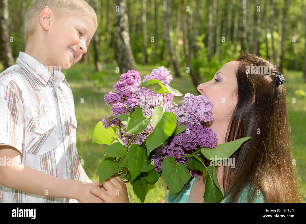 The boy gives flowers to his mother Stock Photo - Alamy