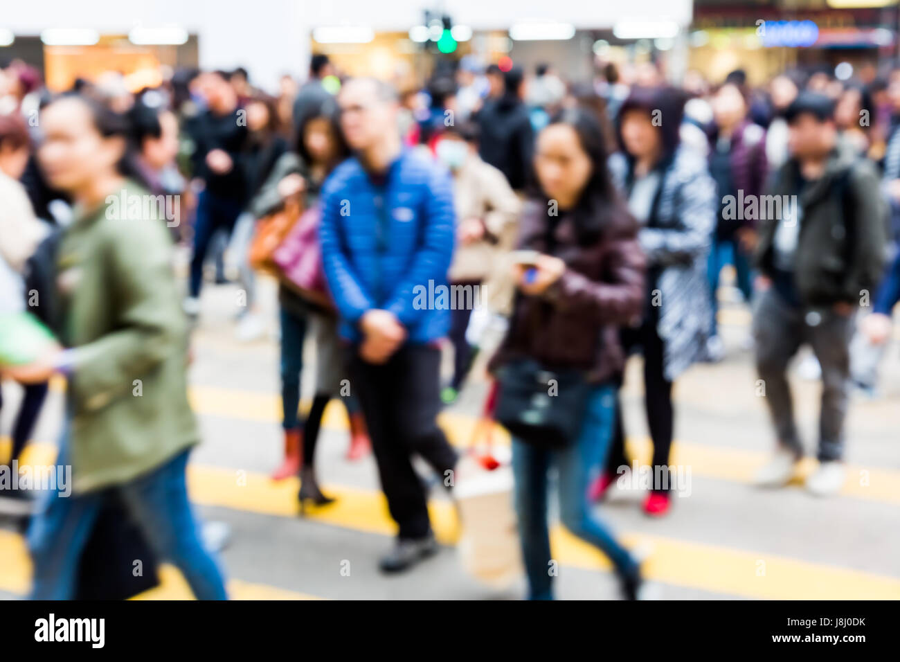crowds of people crossing a city street, out of focus Stock Photo - Alamy