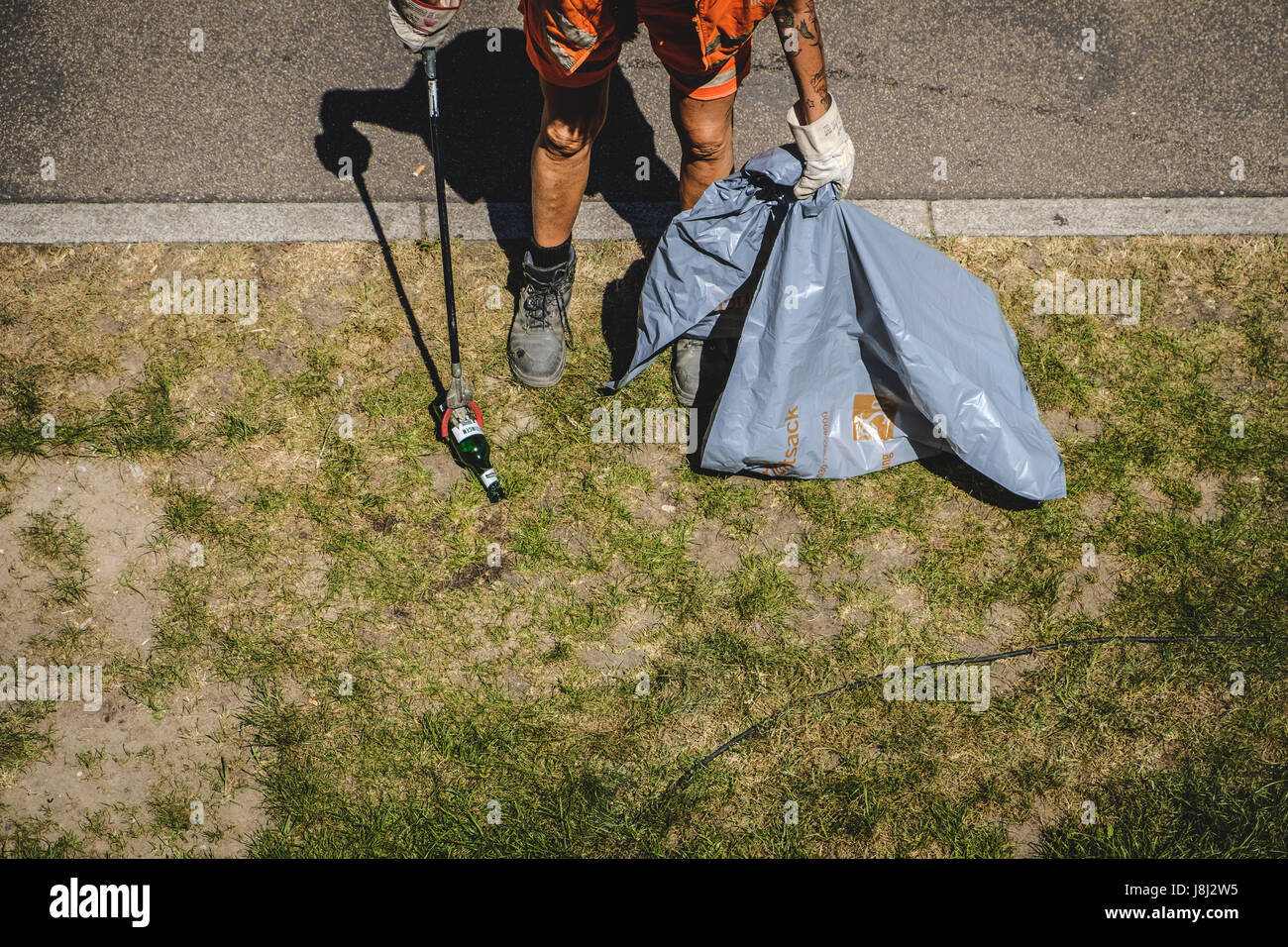 Person cleaning park with a trash grabber - city service worker picking ...