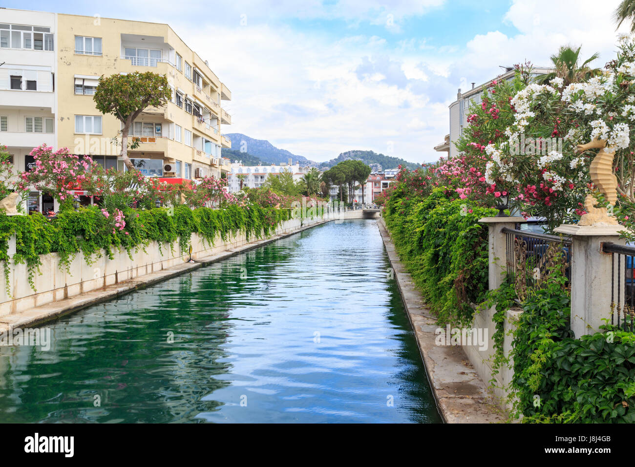 Reflection on canal inside marmaris city with mountains background ...