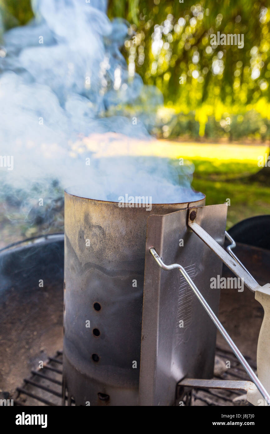A chimney style charcoal starter on a Weber Kettle barbecue Stock Photo ...