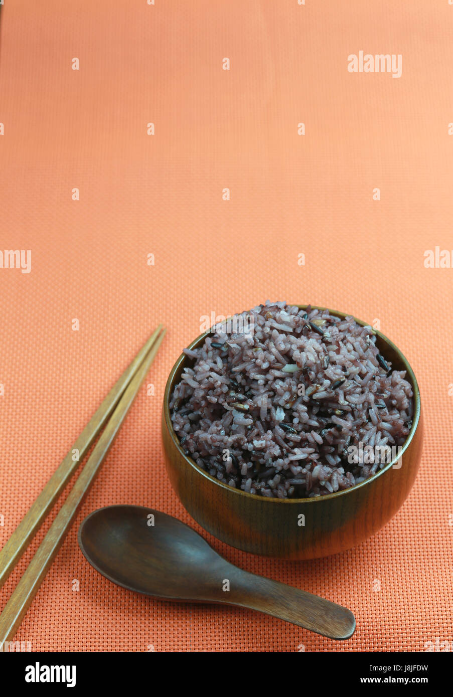 Organic Rice berry in wooden dish on orange plastic background Stock ...