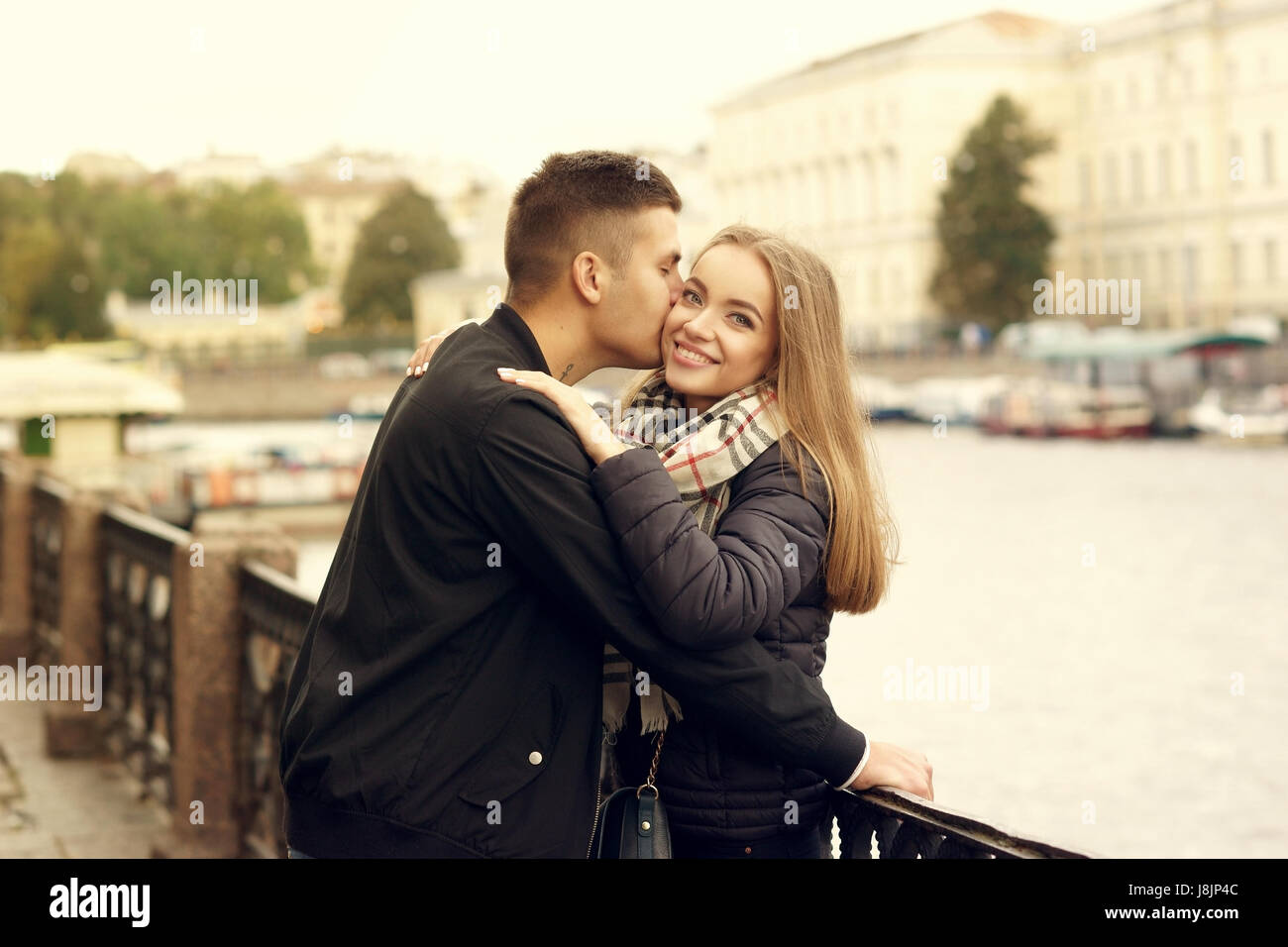 Happy joyful beautiful young romatic couple hugging and cuddling at ...