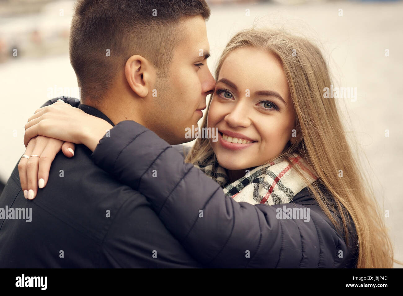Happy joyful beautiful young romatic couple hugging and cuddling at ...