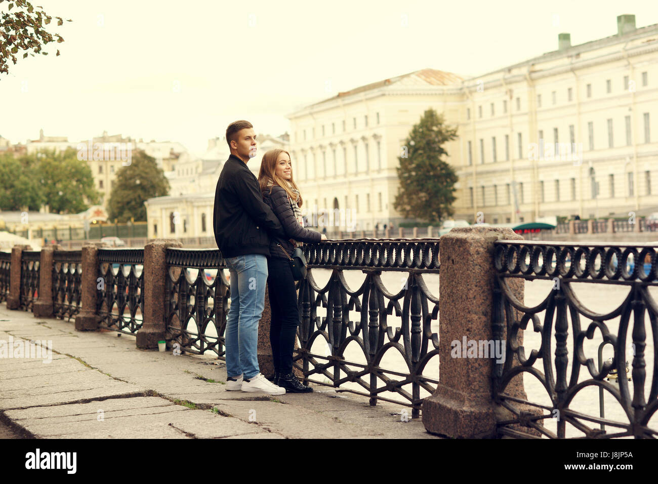 Young caucasian romatic couple in love cuddling at city street standing ...