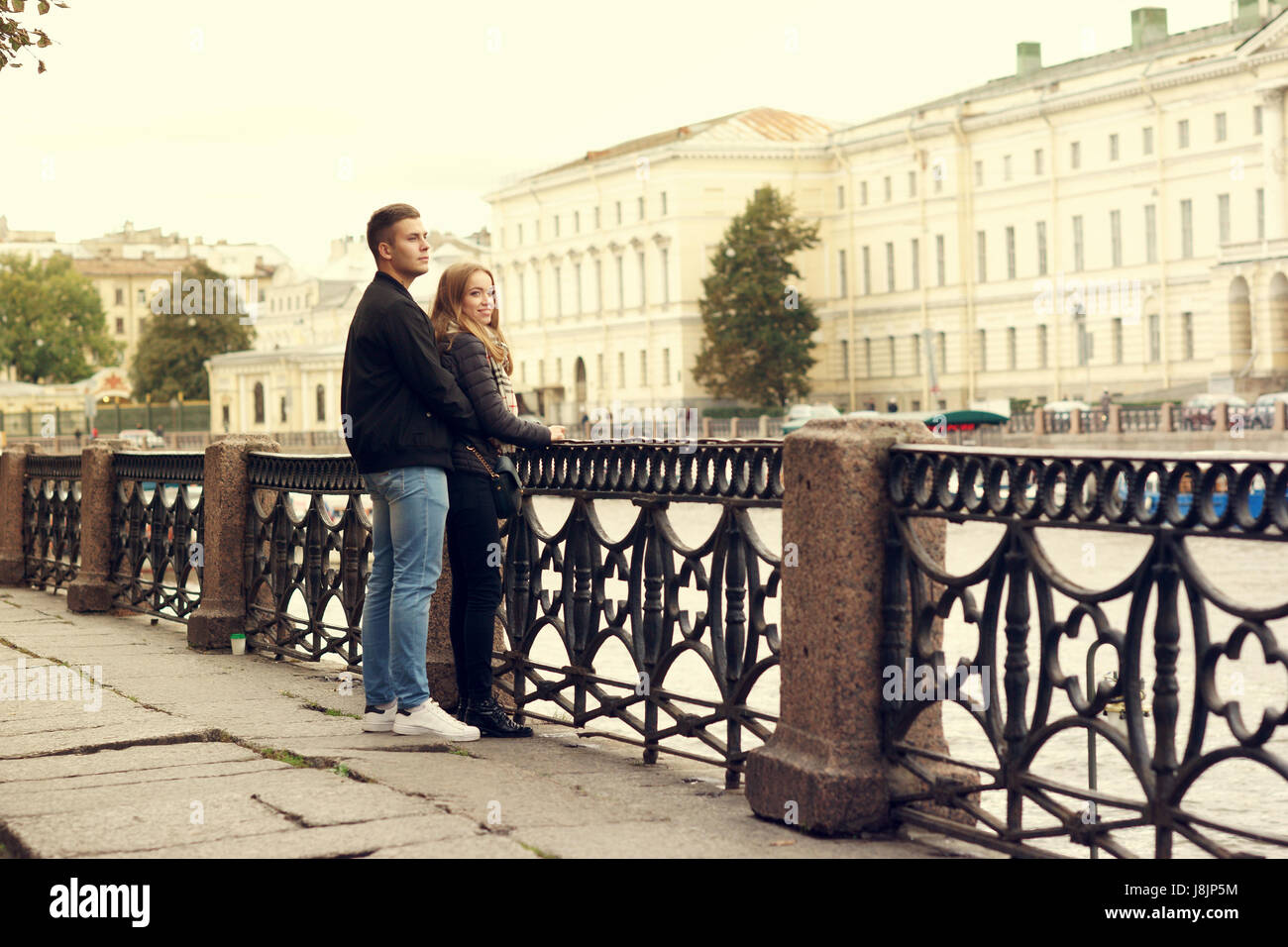 Young caucasian romatic couple in love cuddling at city street standing ...