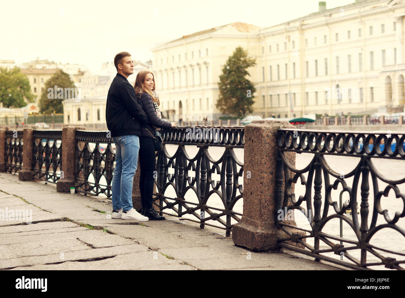 Young caucasian romatic couple in love cuddling at city street standing ...