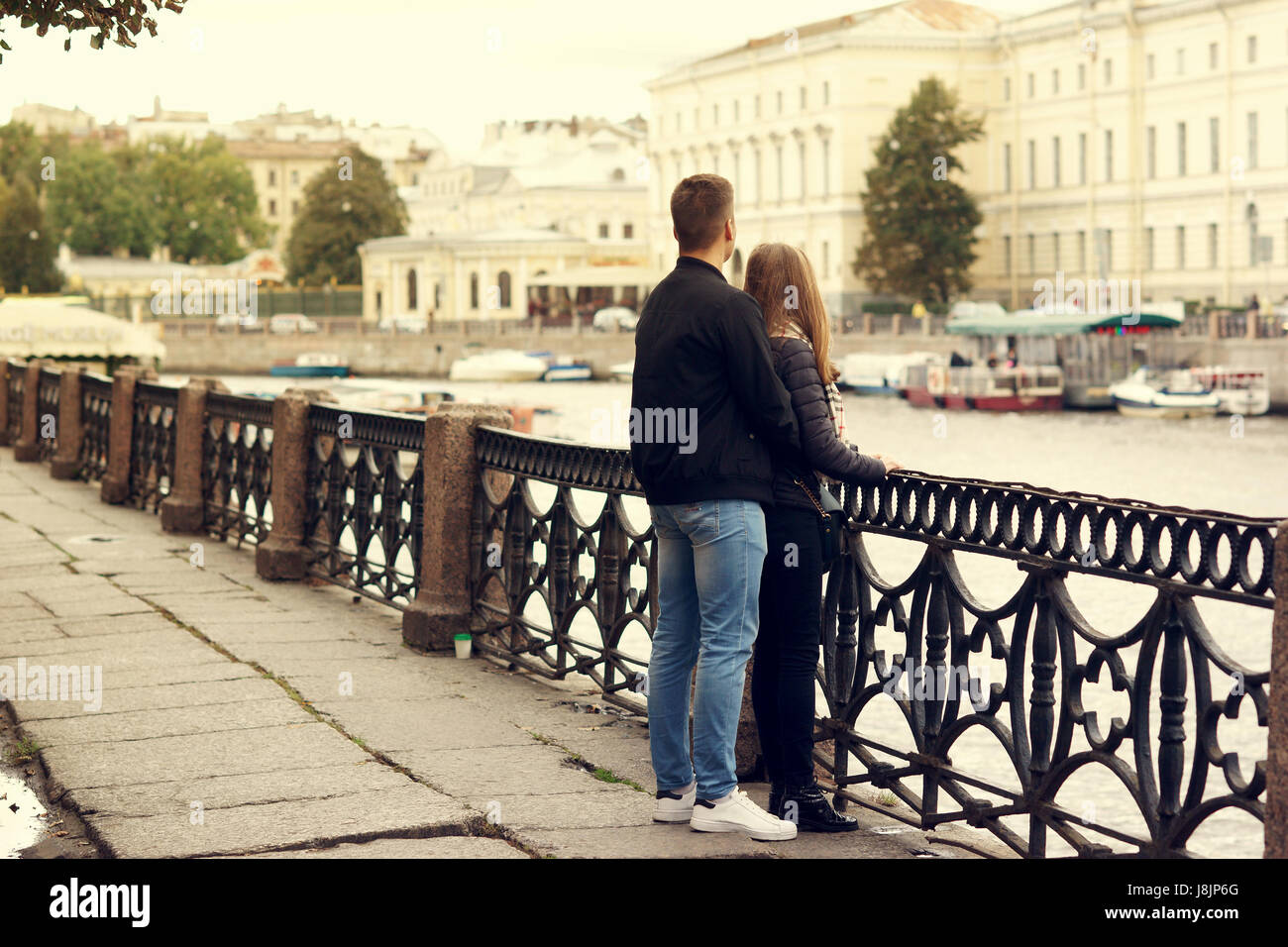 Young caucasian romatic couple in love cuddling at city street standing ...