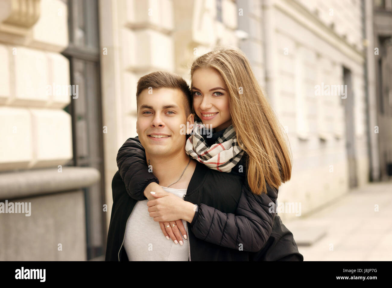 Young happy joyous couple cuddling at city street. Beautiful pretty ...