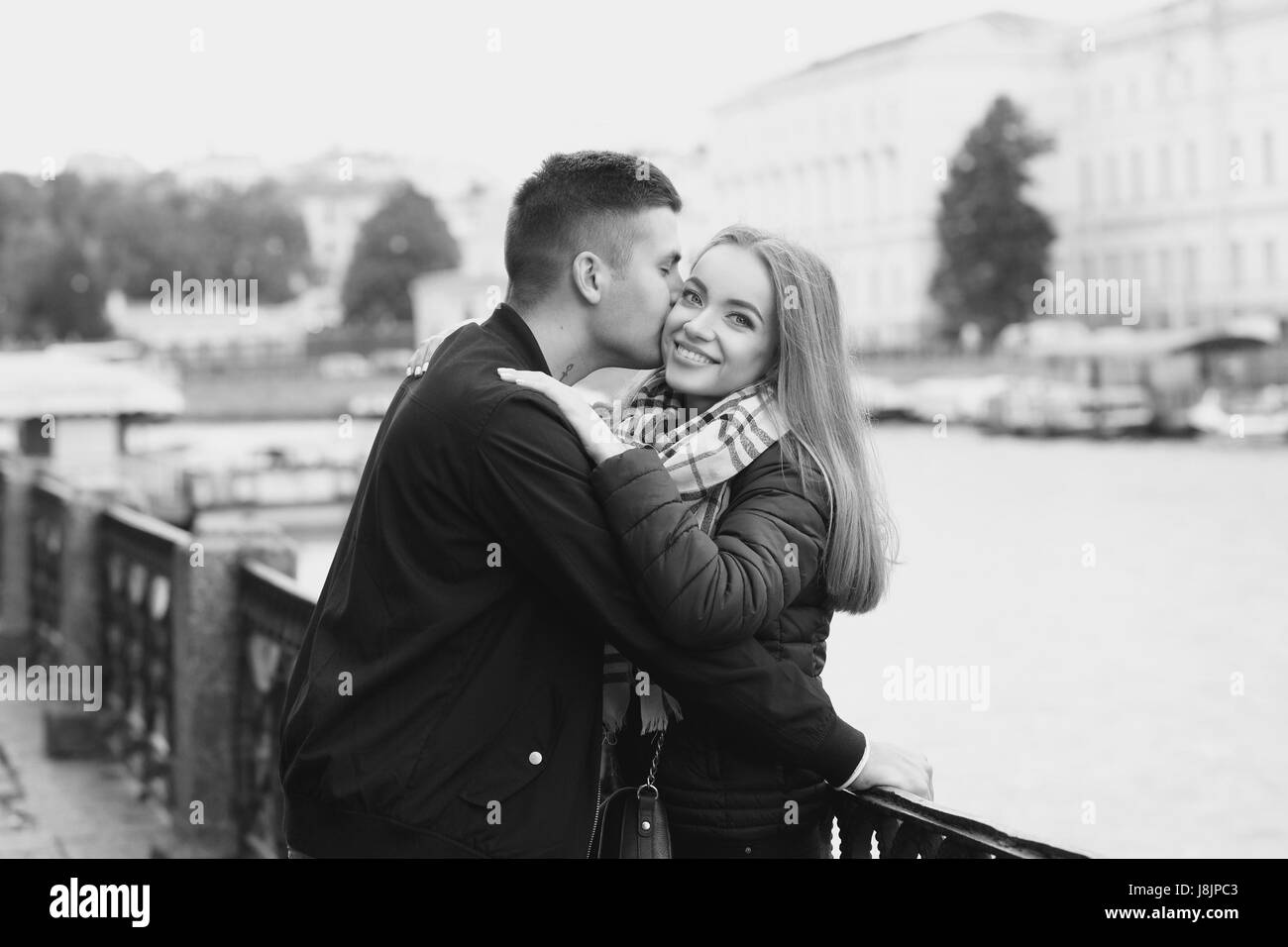 Happy joyful beautiful young romatic couple hugging and cuddling at ...