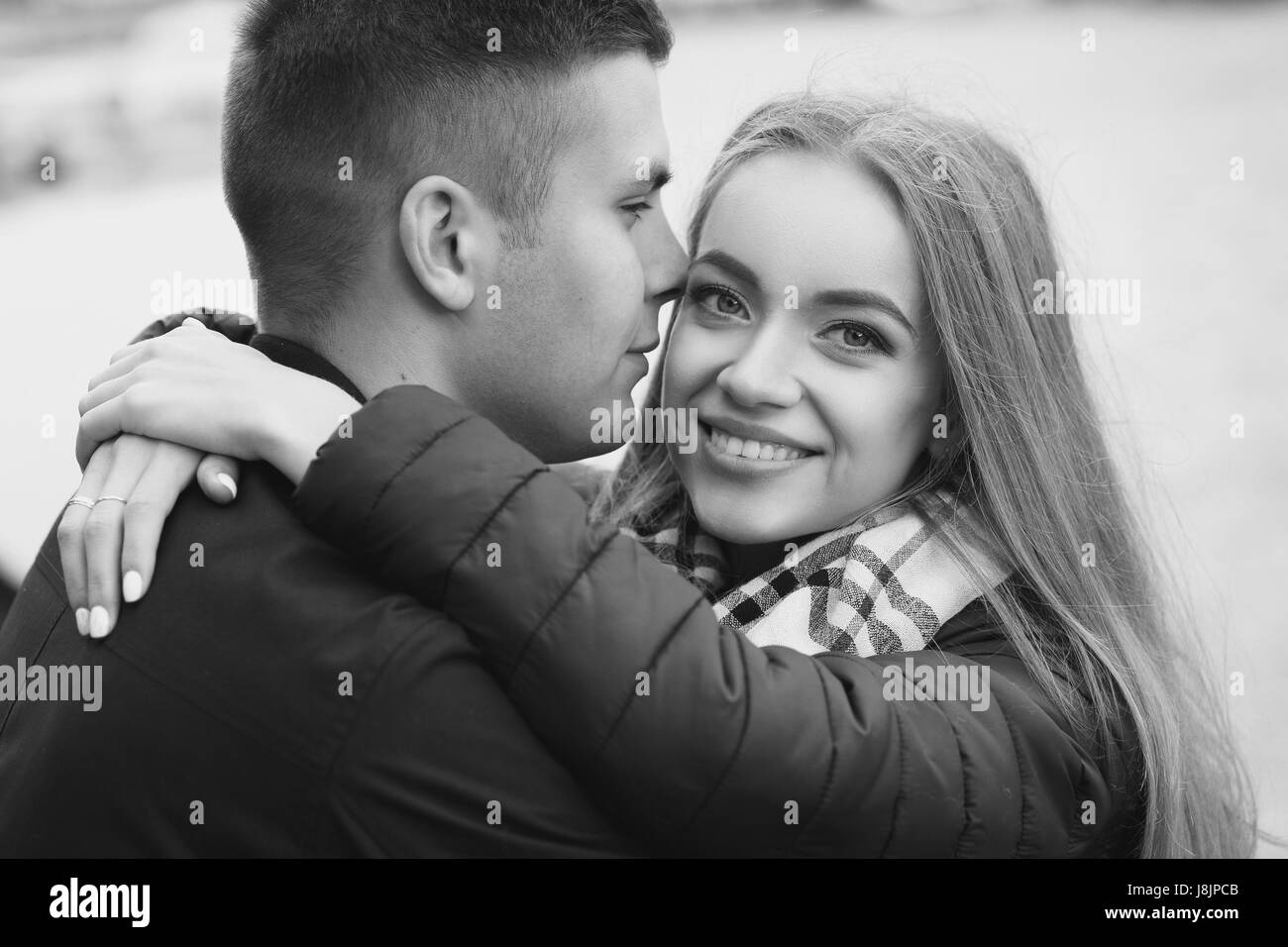 Happy joyful beautiful young romatic couple hugging and cuddling at ...
