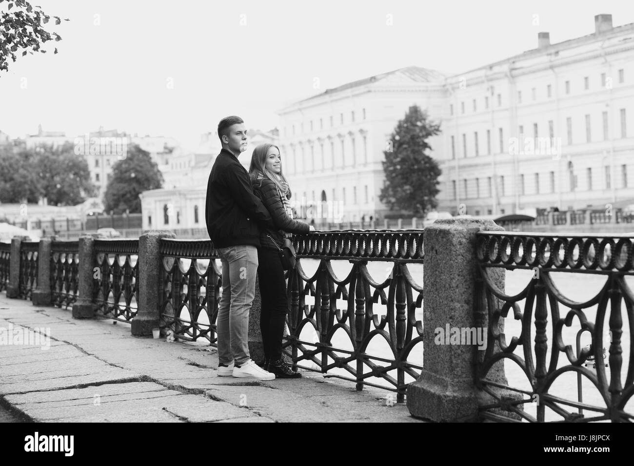 Young caucasian romatic couple in love cuddling at city street standing ...