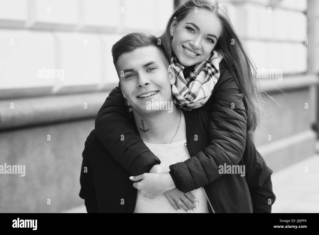 Young happy joyous couple cuddling at city street. Beautiful pretty ...