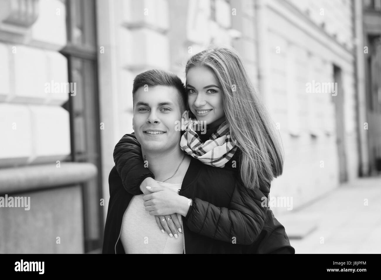 Young happy joyous couple cuddling at city street. Beautiful pretty ...