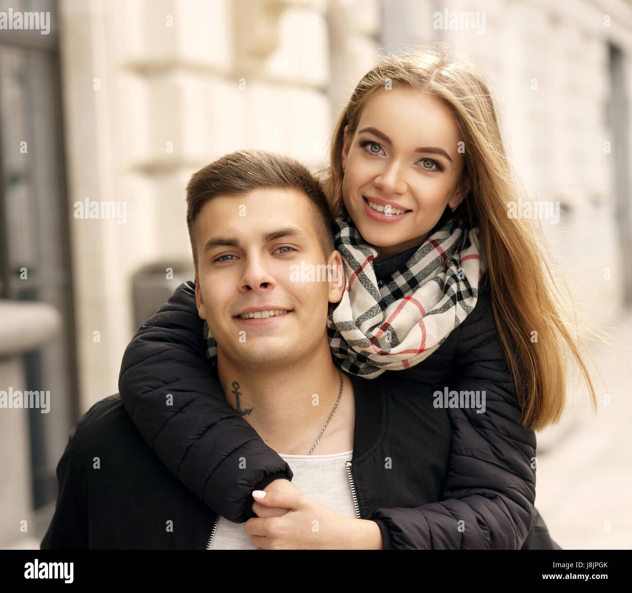 Young happy joyous couple cuddling at city street. Beautiful pretty ...