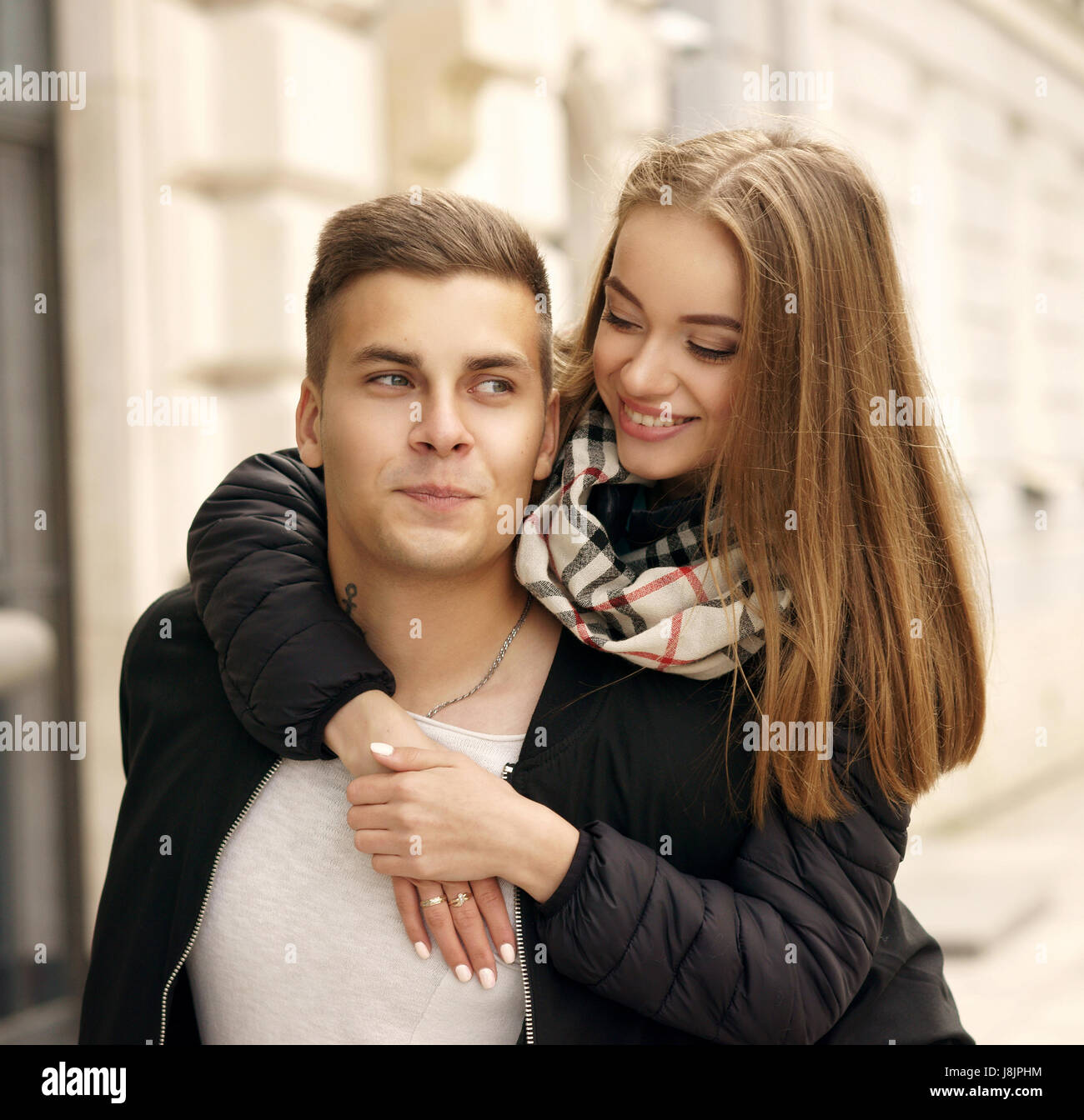 Young happy joyous couple cuddling at city street. Beautiful pretty ...