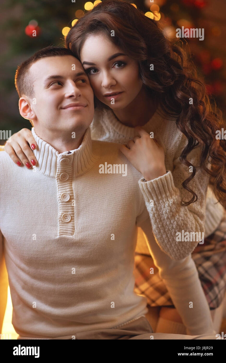 Young couple staying at home together on holiday evening and sitting on ...