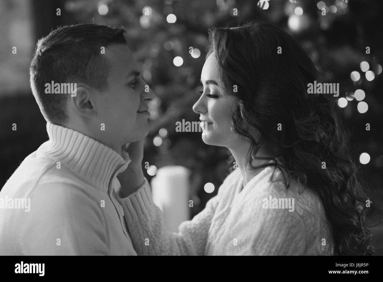 Young couple staying at home together on holiday evening and sitting on ...