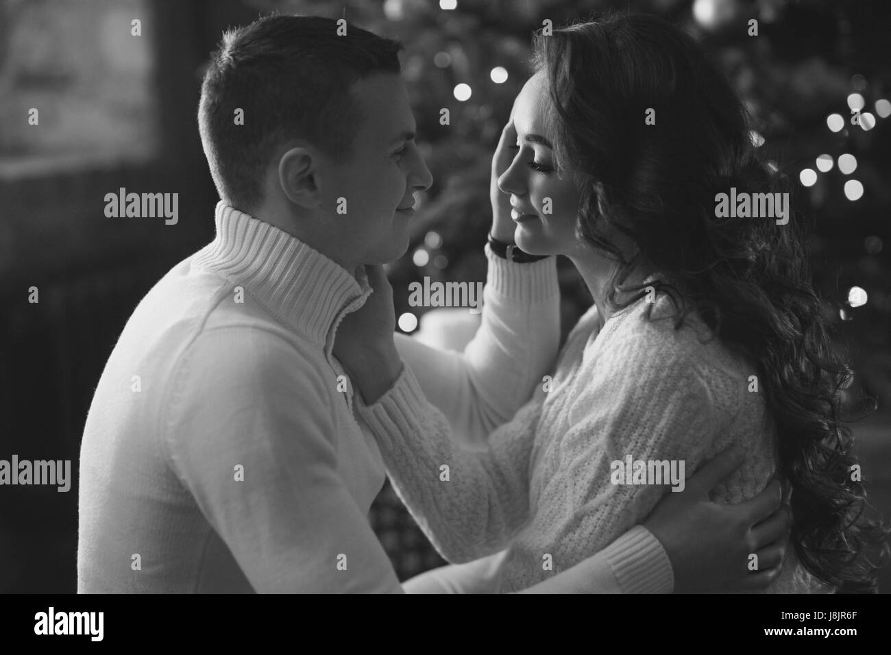 Young couple staying at home together on holiday evening and sitting on ...