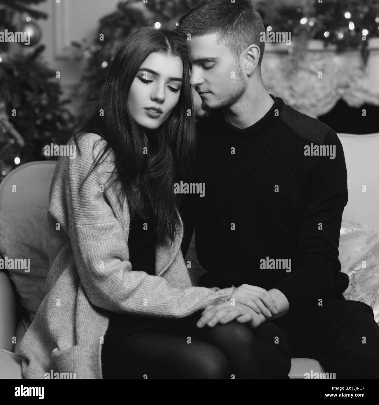 Cute beautiful caucasian young couple sutting at sofa in christmas ...