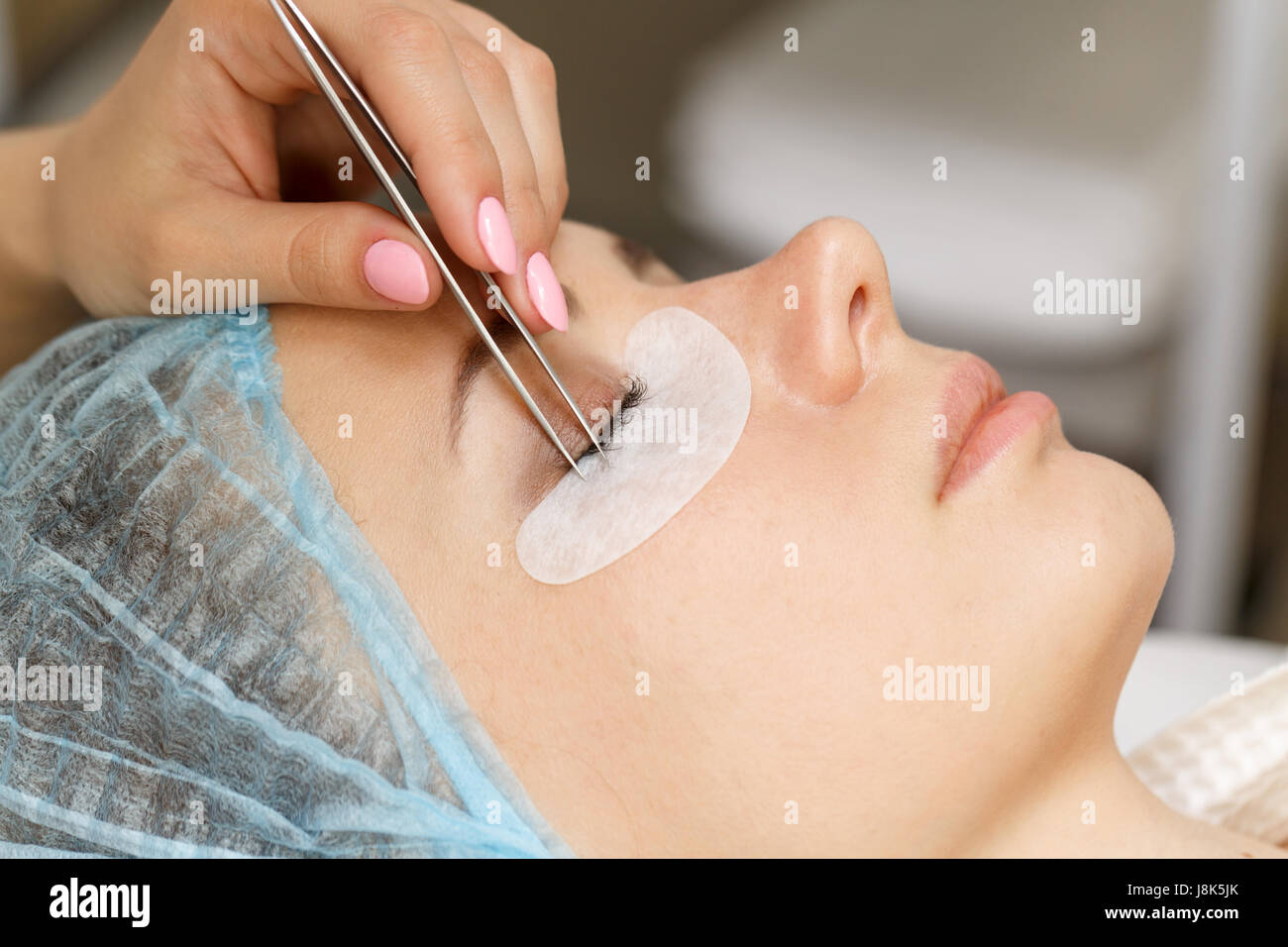 Beauty salon. The procedure of fastening the extended eyelashes ...