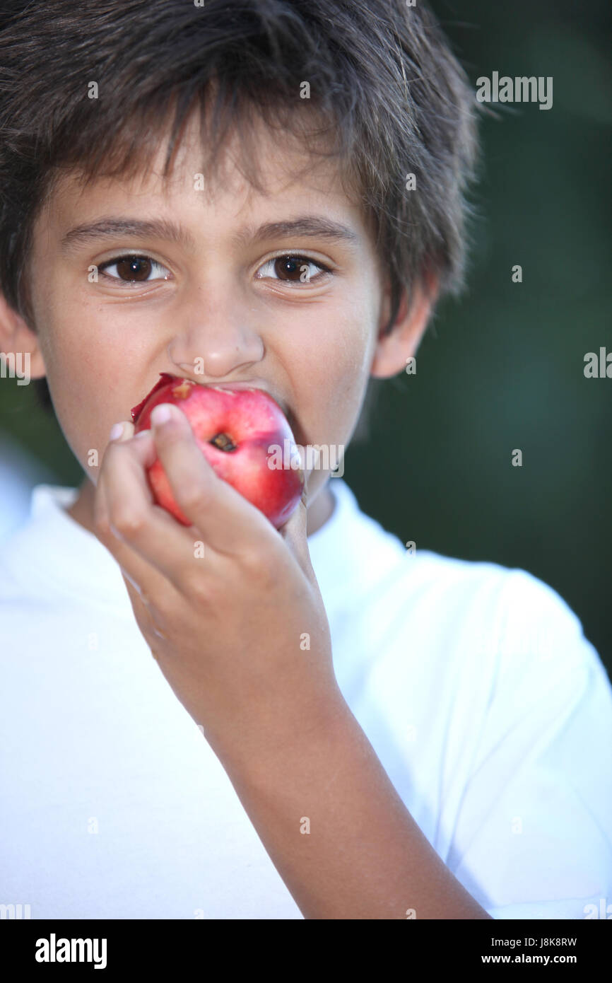 Boy biting peach hi-res stock photography and images - Alamy