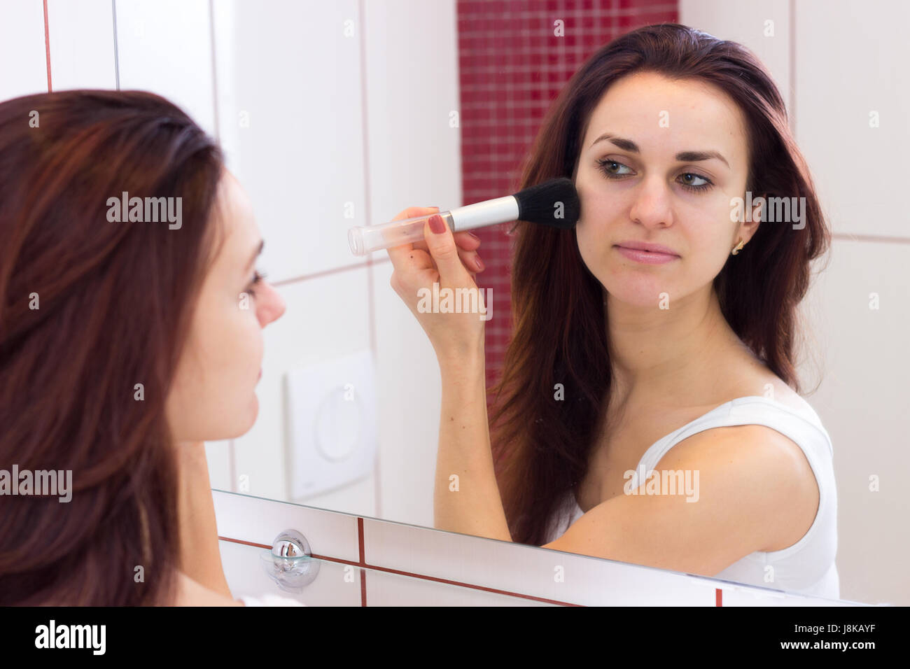 Young woman powdering in bathroom Stock Photo - Alamy
