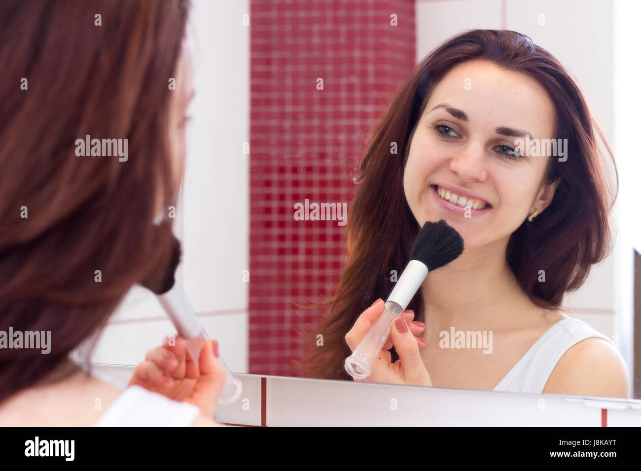 Young woman powdering in bathroom Stock Photo - Alamy
