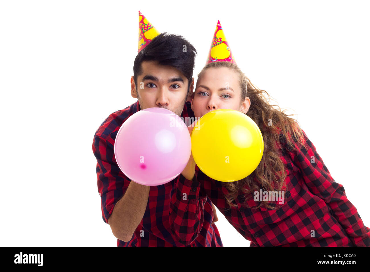 Young couple blowing balloons Stock Photo - Alamy