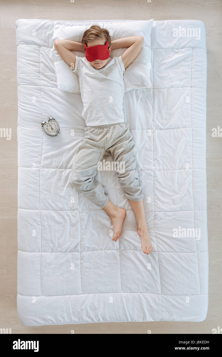 For better sleep. Cute nice blonde boy wearing a sleeping mask and ...