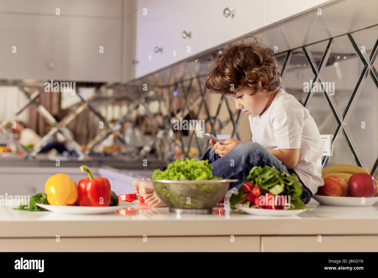 Cute adorable little boy in the kitchen. Boy sitting on the kitchen ...