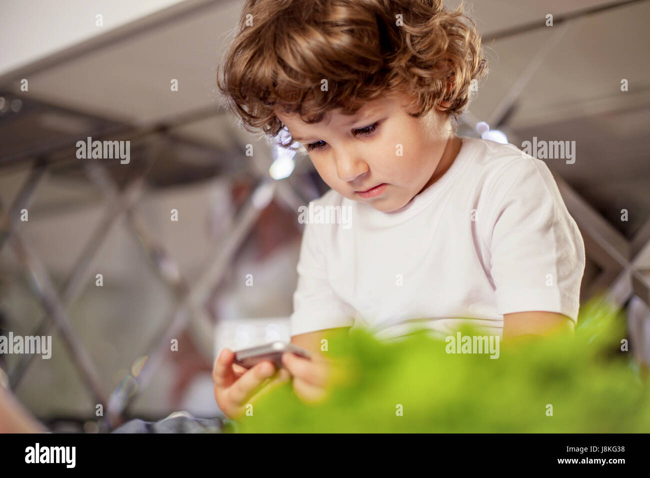 Little cute boy sitting with the phone in his hands Stock Photo - Alamy