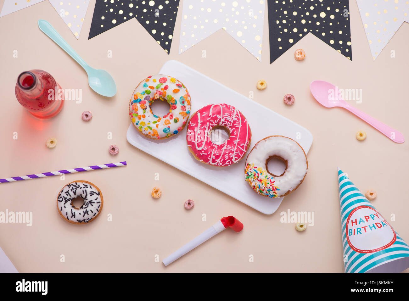 Party. Different colourful sugary round glazed donuts and bottles of ...