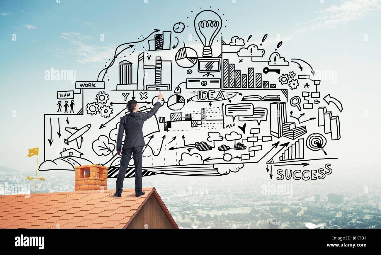 Rear view of businessman on house roof drawing his new business Stock ...