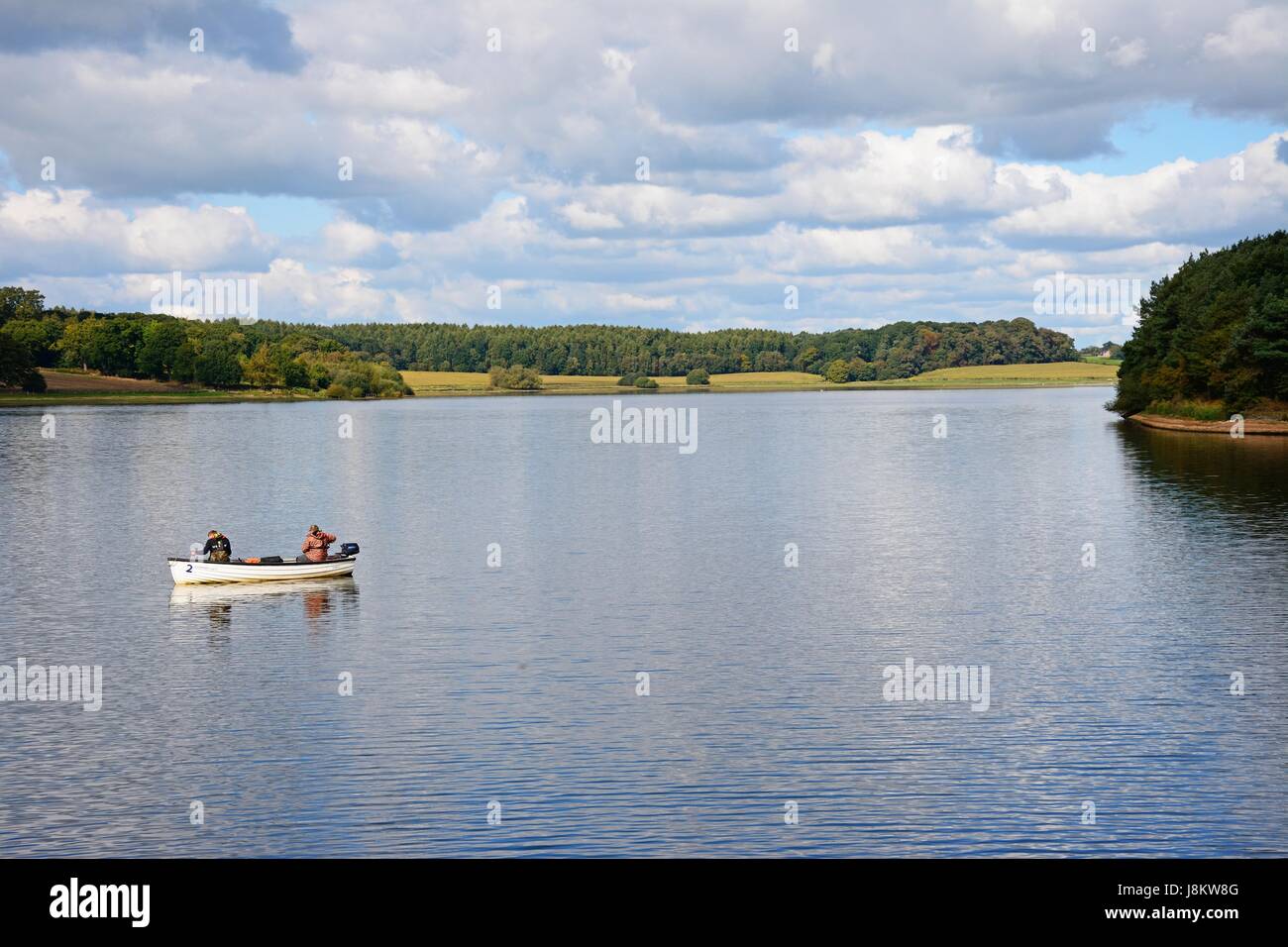 View across Blithfield reservoir with a small boat to the left hand ...