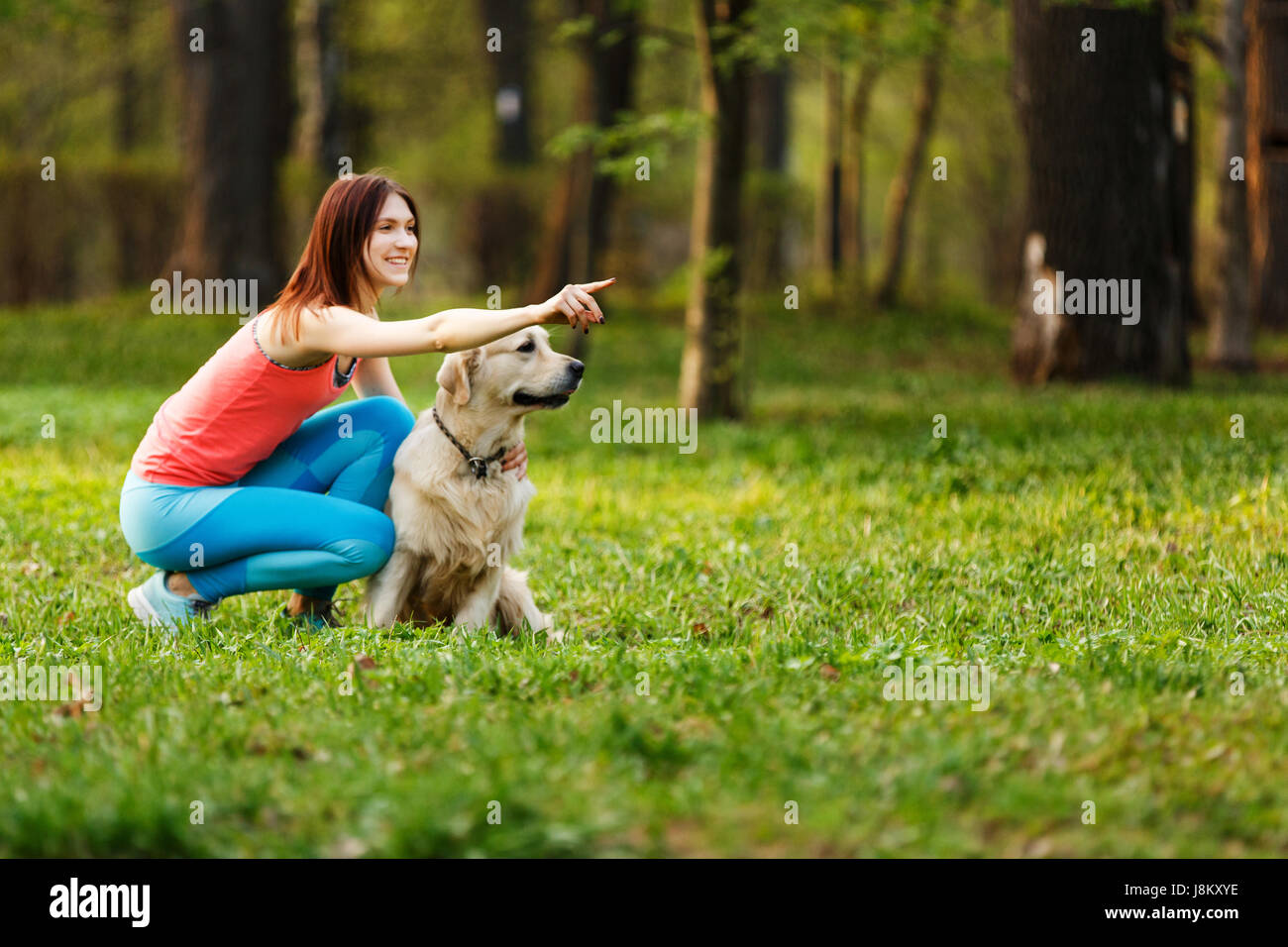 Woman gives command to dog Stock Photo - Alamy
