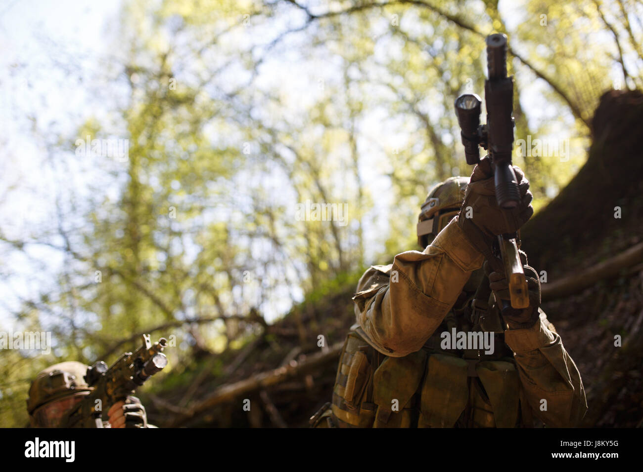 Soldier with gun in forest Stock Photo - Alamy