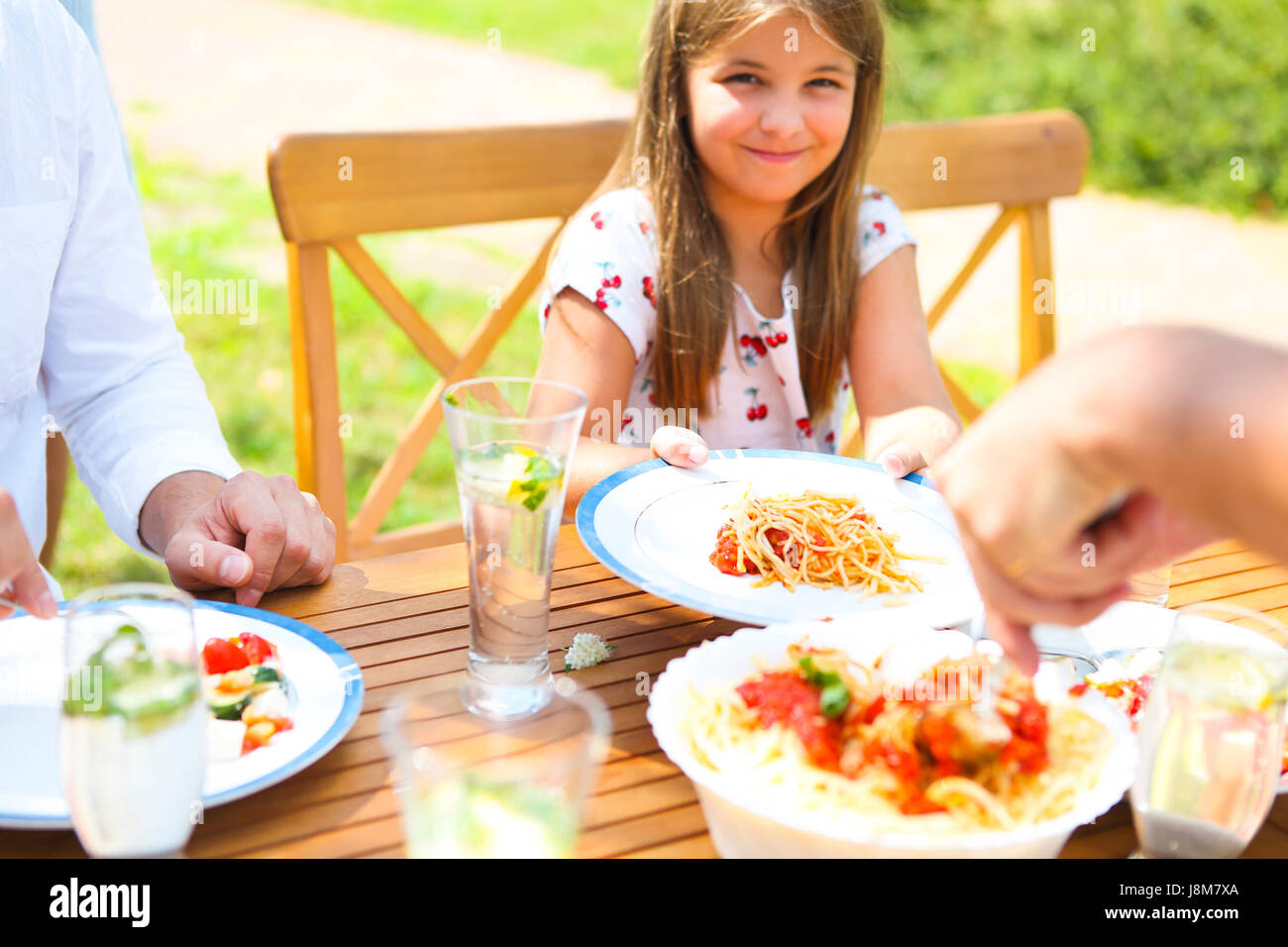 Family dinner variety of Italian dishes on wooden table in the garden ...
