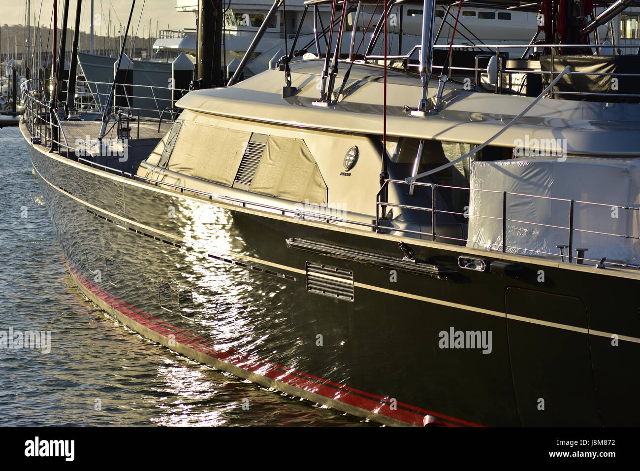 Water surface reflections on sailing ship dark hull in late evening ...