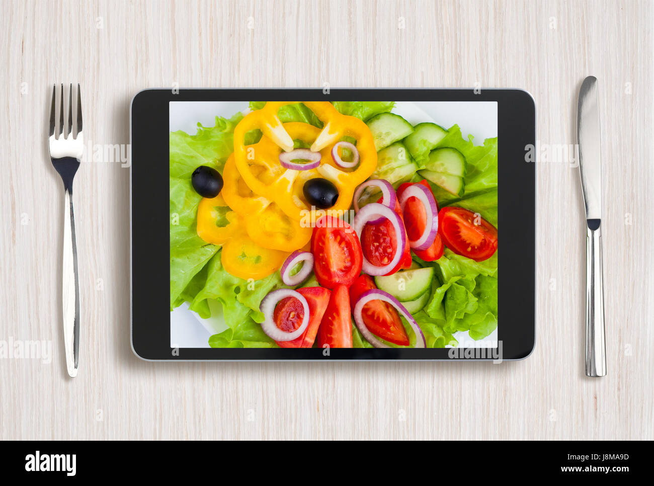 black tablet pc with healthy food on screen and wooden table Stock ...
