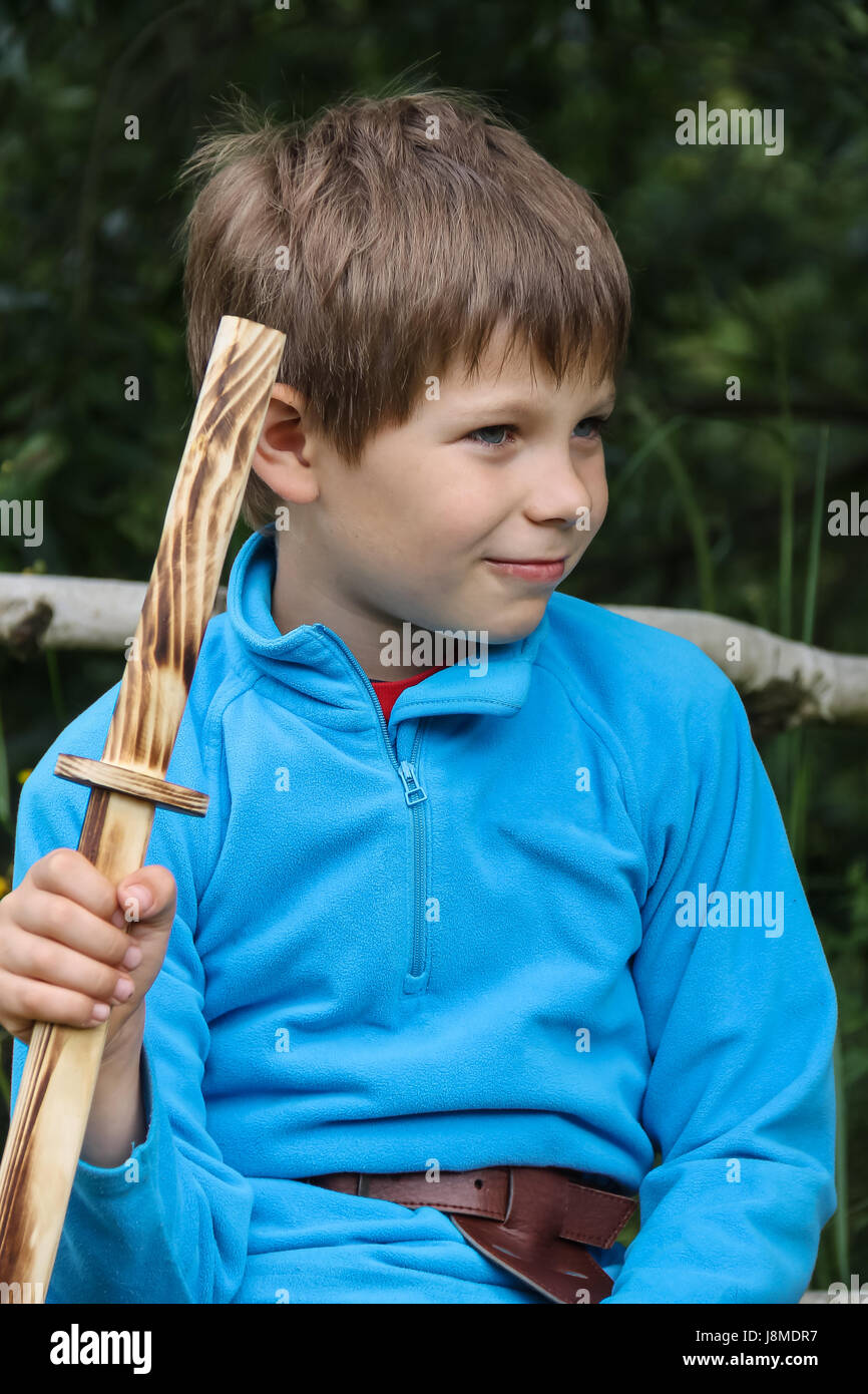 Boy with wooden sword in summer forest park Stock Photo - Alamy
