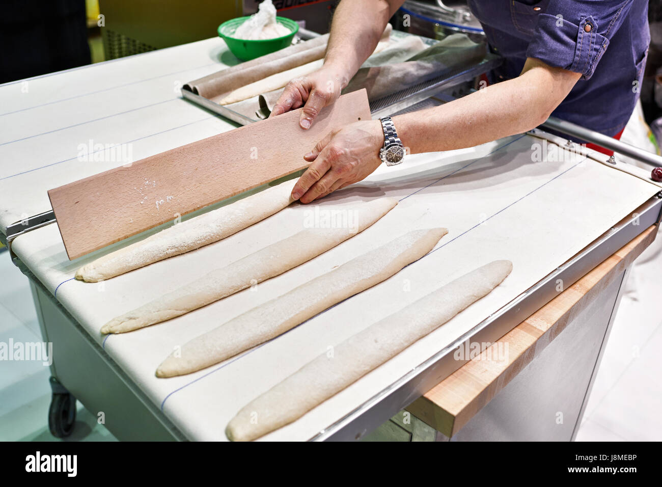 Baker prepares bread before baking at bakery Stock Photo - Alamy